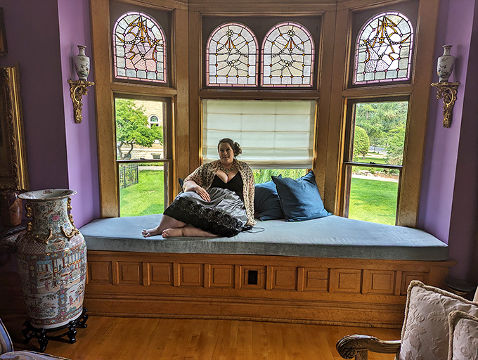 A window seat that's essentially an invitation to cancel all your plans, grab a book, and disappear for hours. The stained glass is just showing off.