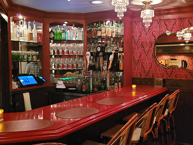 The bar at L'Auberge doesn't just serve drinks&mdash;it serves atmosphere. That rich red counter has probably heard more dinner plans and declarations of love than a romance novelist.