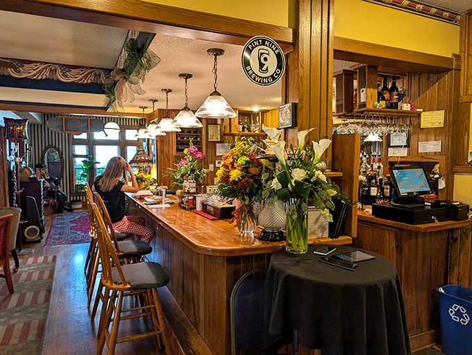 The bar area balances casual comfort with refined charm. Fresh flowers and warm wood tones create a space where both cocktails and conversations flow easily.