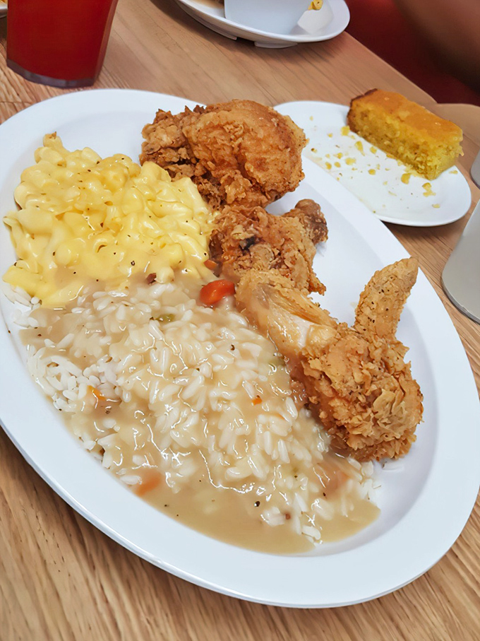 A perfect trinity of Southern comfort: crispy fried chicken, creamy mac and cheese, and rice smothered in gravy that could settle family feuds.