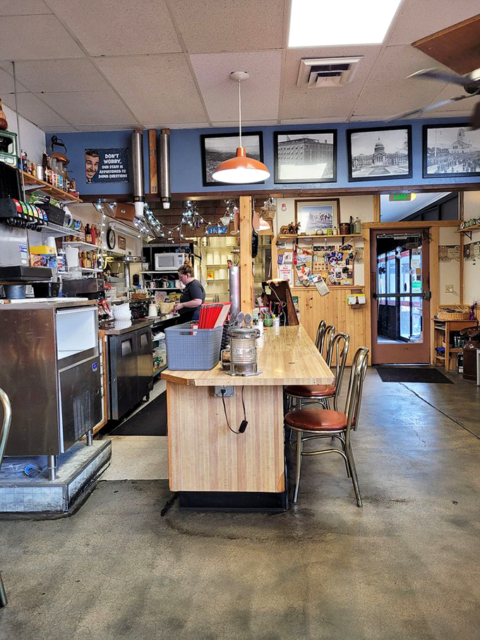 The counter view&mdash;where breakfast magic happens. Worn wood, pendant lights, and a blue accent wall displaying historic Boise photographs tell you this place has roots.