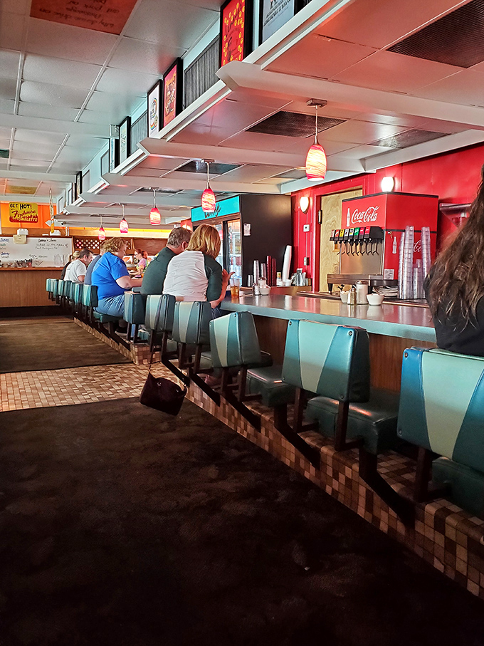 The counter at Lenny's &ndash; where solo diners become temporary family, sharing coffee refills and life stories under the warm glow of vintage pendant lights.