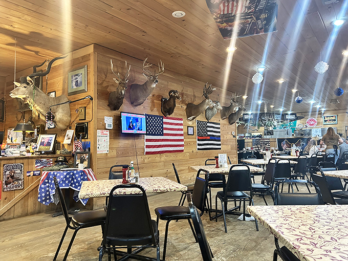 The dining room's mounted trophies seem to watch over guests with approval, while tables draped in patterned cloths await the next round of happy diners.