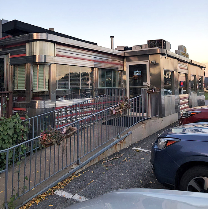 As dusk settles, the diner's illuminated exterior beckons hungry travelers like a chrome-clad lighthouse guiding ships to safe harbor.