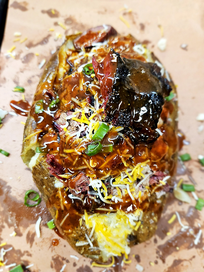 A loaded baked potato that's having an identity crisis—is it a side dish or a complete meal? With that mountain of toppings and burnt end crown, who cares?