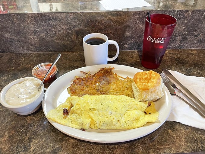 Breakfast of champions: a fluffy omelet, crispy hash browns, and a biscuit that could make a grown man weep. Coffee mandatory.