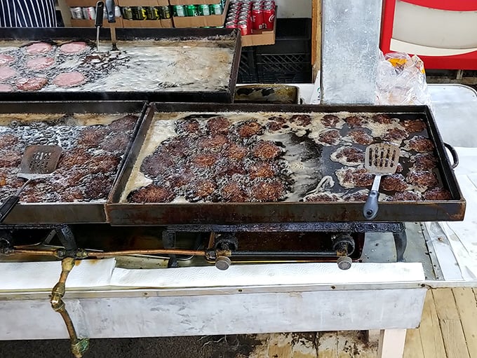 The sacred flat-top where burger alchemy happens. Those perfectly "squeezed" patties develop a crust that should be studied by scientists.