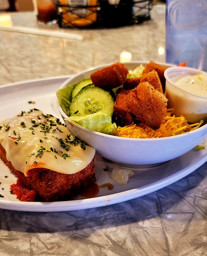 A hearty meatloaf topped with melted cheese alongside a fresh side salad. Who says you can't have the best of both worlds?