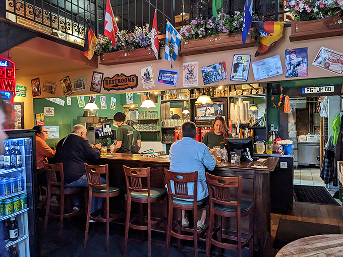 European flags stand guard over the bar like colorful sentinels ensuring your glass remains full and your spirits high.