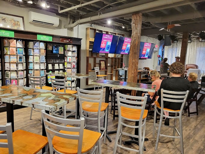 The caf&eacute; seating area transforms into an impromptu literary salon where strangers bond over dog-eared pages and fresh perspectives.