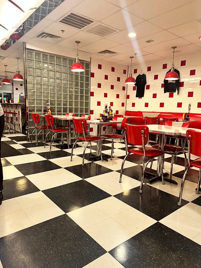 Red chairs await their next occupants like old friends ready for a catch-up session. The checkerboard floor practically begs you to make your next move toward the menu.