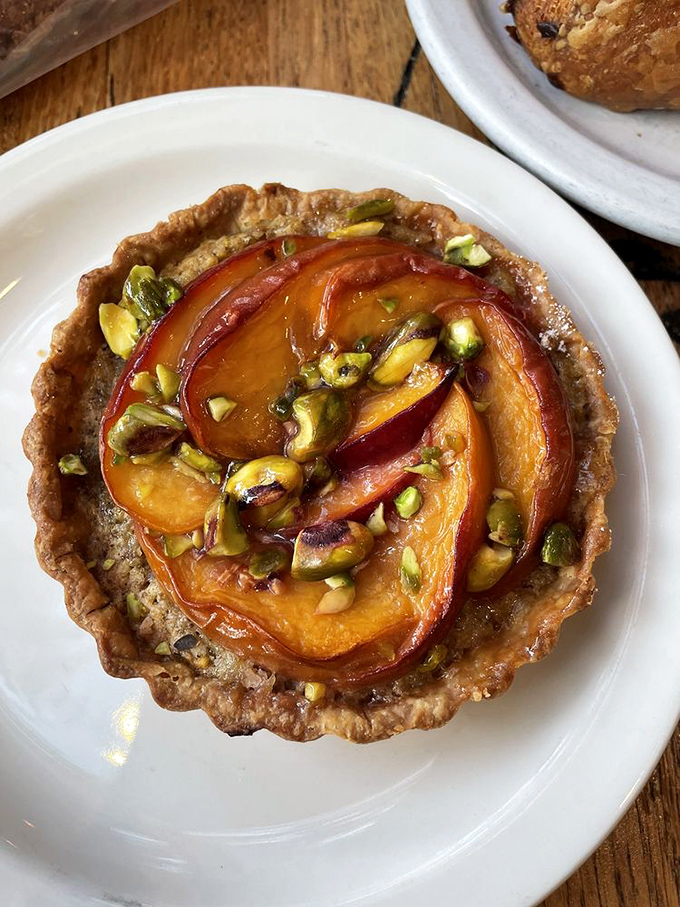 Behind the counter, where dreams are baked daily. The bread display glows like a museum exhibit, except touching is not only allowed but encouraged. 