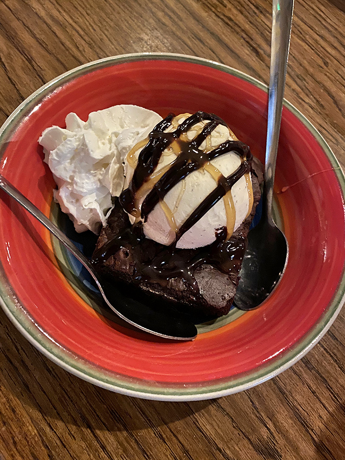 A warm brownie crowned with ice cream that's melting just right. The chocolate drizzle is writing love poems to your taste buds. 