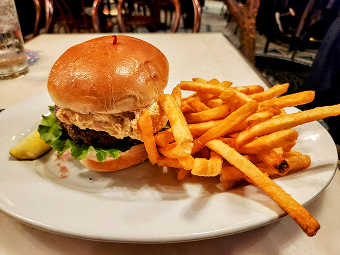 A burger that demands two hands and your full attention, with fries so perfectly golden they deserve their own Instagram account.