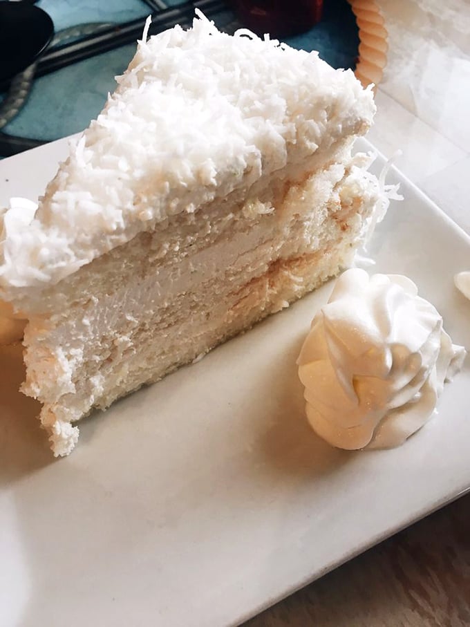 The coconut cake finale&mdash;a towering sweet achievement that somehow finds room in stomachs already full of prime rib. The perfect ending to a legendary meal.