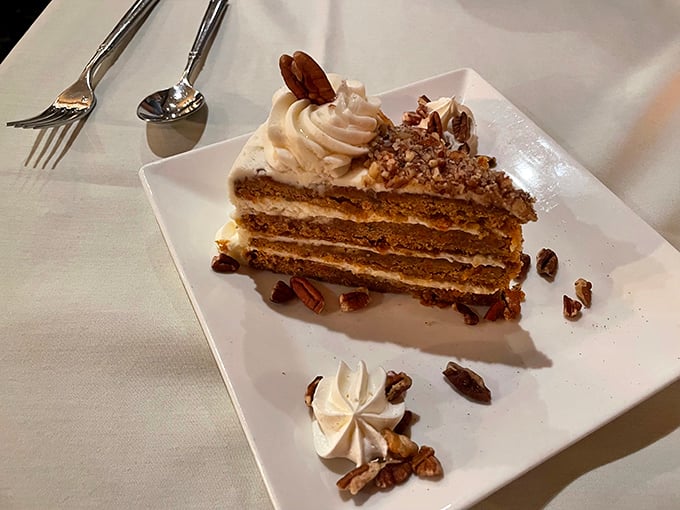 Layer upon layer of cake goodness, where each forkful is a sweet expedition through cream, cake, and crunchy pecan terrain.