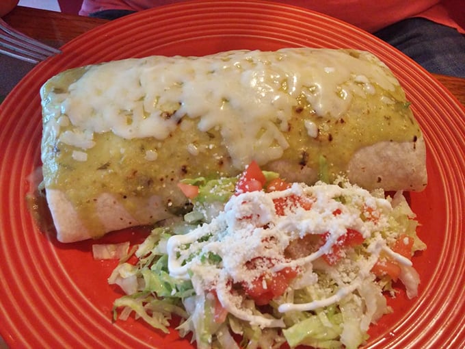 This burrito smothered in verde sauce isn't just a meal – it's a commitment to happiness that requires both a fork and a nap afterward.
