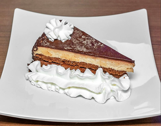 A slice of chocolate cake so decadent it should come with its own warning label: "May cause spontaneous expressions of joy and requests for seconds."