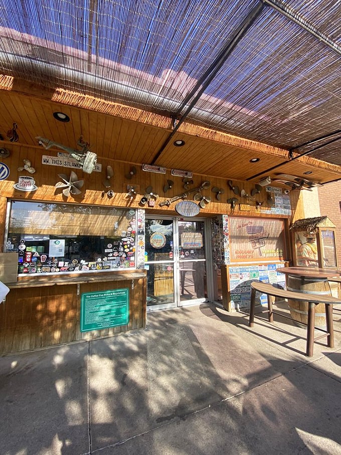 Step into sticker paradise. The entrance to The Coffee Cup Cafe promises both shade and the kind of authentic experience that keeps people coming back.