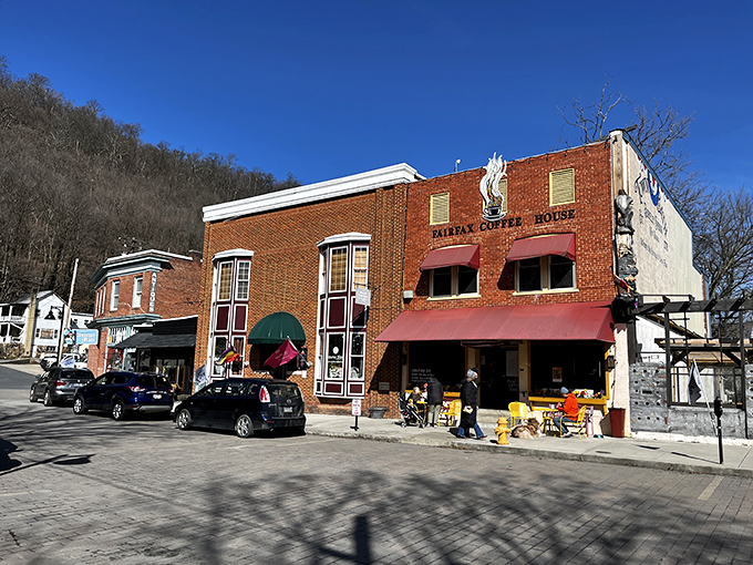 Fairfax Coffee House anchors the corner with brick-solid confidence. Those outdoor tables have witnessed more deal-making than most boardrooms.