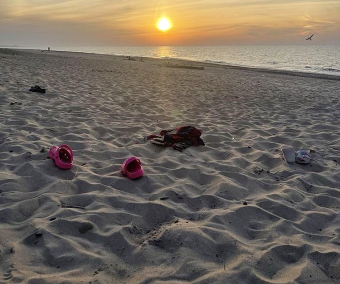 Footprints and flip-flops marking the day's end. As the sun dips below the horizon, abandoned sandals become temporary monuments to a perfect beach day.