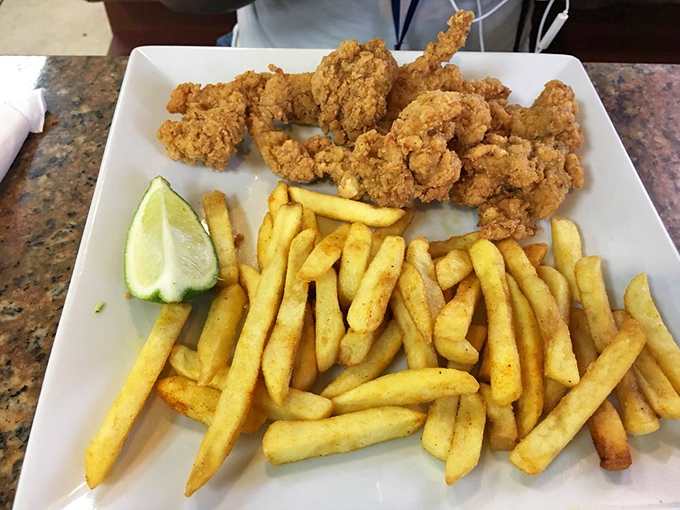 Crispy fried conch and golden fries with a lime wedge standing by&mdash;seafood that tastes like the ocean took a delicious detour through the Deep South