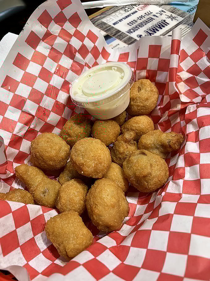 Mushroom poppers nestled in their red checkered cradle. These golden orbs of joy aren't just appetizers&mdash;they're little portals to happiness.
