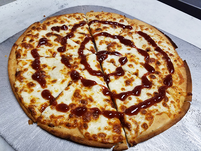 BBQ sauce drizzled over melted cheese is proof that someone in this kitchen understands the architecture of flavor. Pizza perfection with a smoky twist.