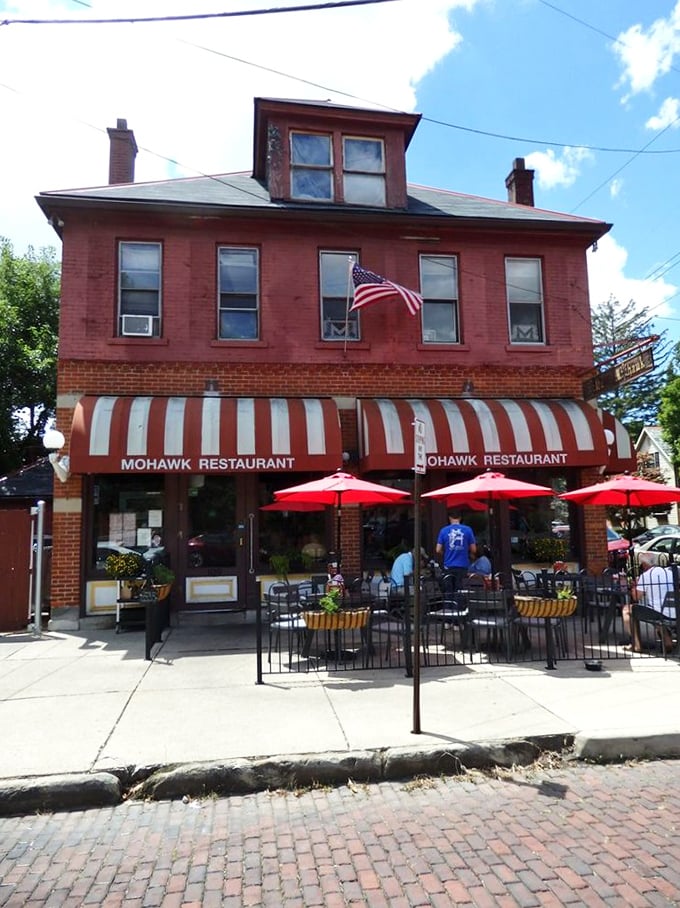 Summer perfection: red umbrellas, outdoor seating, and that distinctive brick building housing all the comfort food your heart desires.