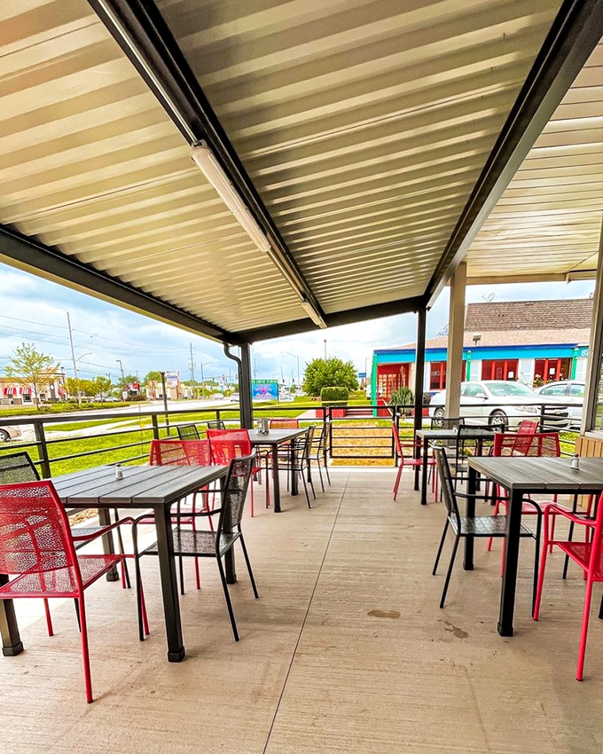 The outdoor patio: where fresh air meets fresh flavors. Those red chairs aren't just seating; they're front-row tickets to a memorable meal.
