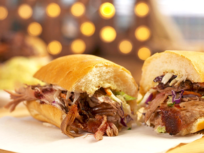 This pulled pork sandwich isn't just lunch&mdash;it's edible architecture. The golden-crusted French bread cradles its smoky treasure with appropriate reverence.