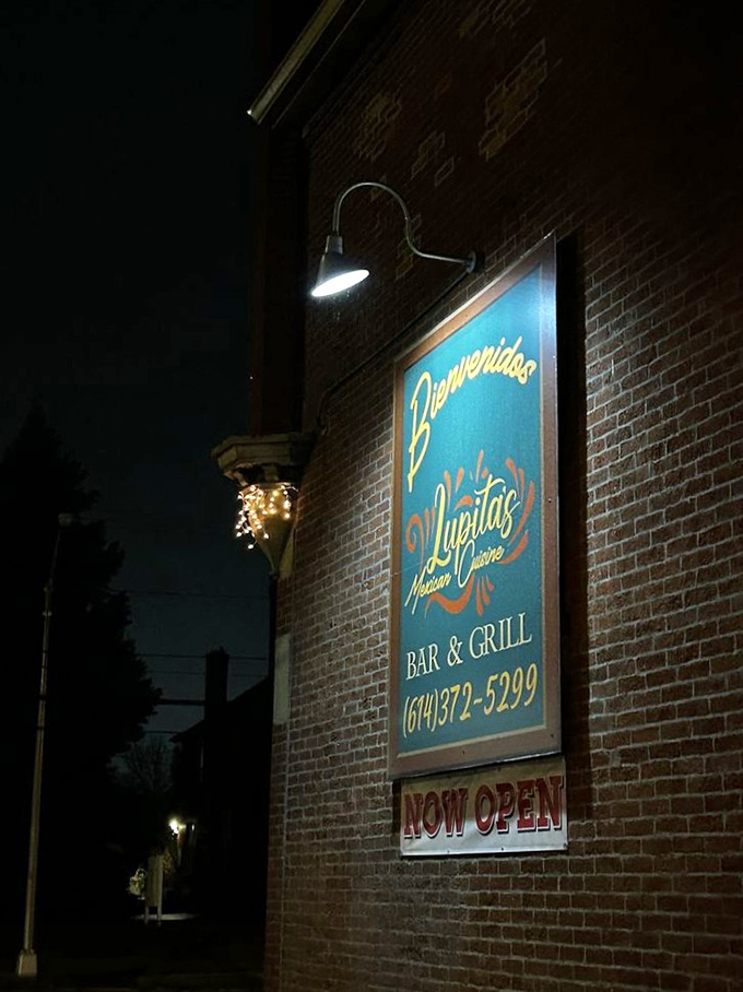 "Bienvenidos" glows against the brick exterior, a nighttime invitation that translates universally to "Get in here and eat something amazing."