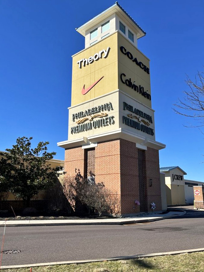 The iconic tower stands like a retail lighthouse, guiding discount enthusiasts to shores where Theory, Nike, Coach, and Calvin Klein await at tempting prices.