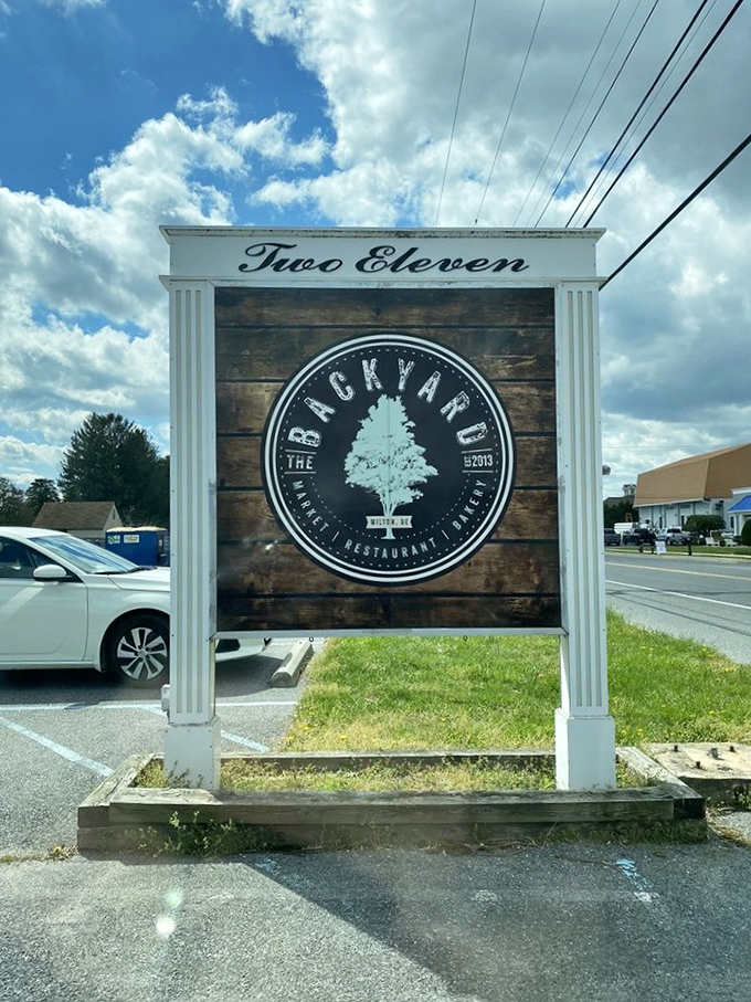 The roadside sign stands as a beacon to hungry travelers, promising delicious refuge from both hunger and highway monotony.