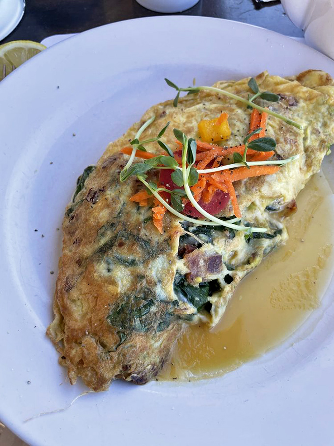 This isn't just an omelet; it's a fluffy golden envelope delivering a message of spinach, herbs and cheese directly to your happiness receptors.