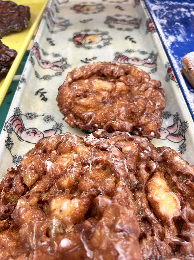Apple fritters lined up for inspection like sugary soldiers, each one unique in its lumpy, cratered glory, waiting to be chosen for greatness.