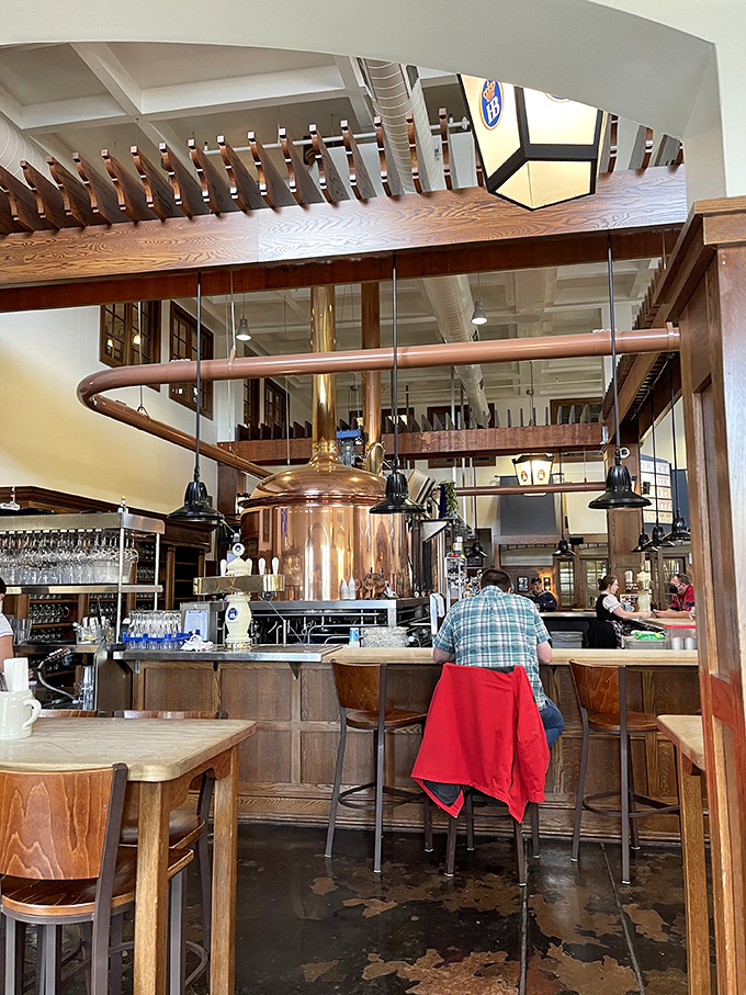 Where the magic happens: copper brewing kettles gleam like treasures, promising liquid gold to thirsty patrons at the bar below.