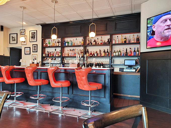 The bar where strangers become friends and those vibrant red chairs practically dare you not to have a good time.
