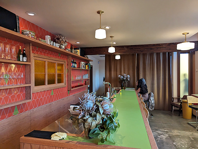 A bar counter where magic happens, with coral-hued tiles adding warmth. The kind of spot where strangers become friends over shared food revelations.