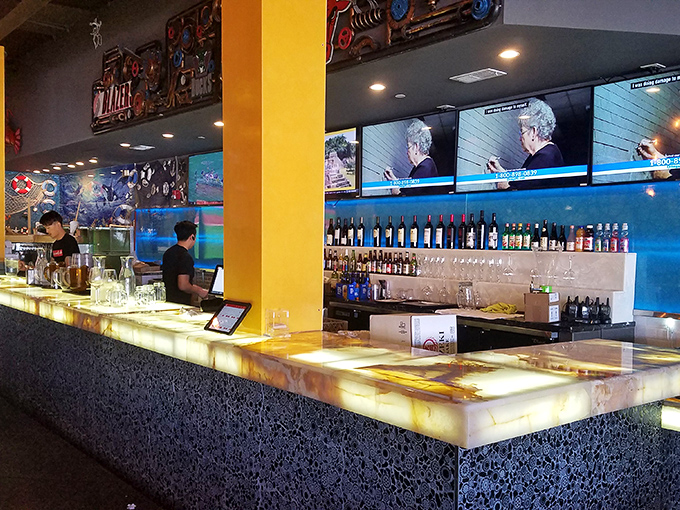 The illuminated bar where liquid courage is dispensed before your second round at the buffet. Strategic hydration headquarters for marathon eaters.