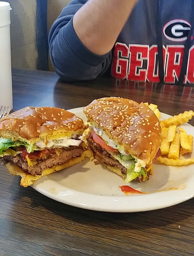 A burger so substantial it has its own gravitational pull. The Georgia Bulldogs fan in the background understands true commitment.