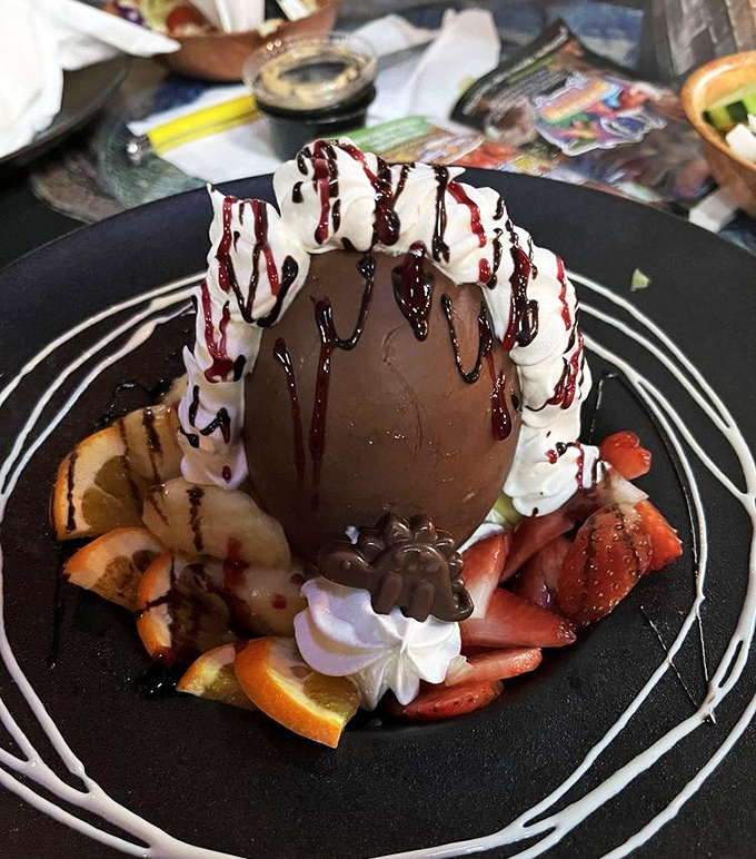 Dessert that would make cavemen weep with joy. A chocolate dome surrounded by fresh fruit and whipped cream&mdash;archaeology never tasted so sweet.