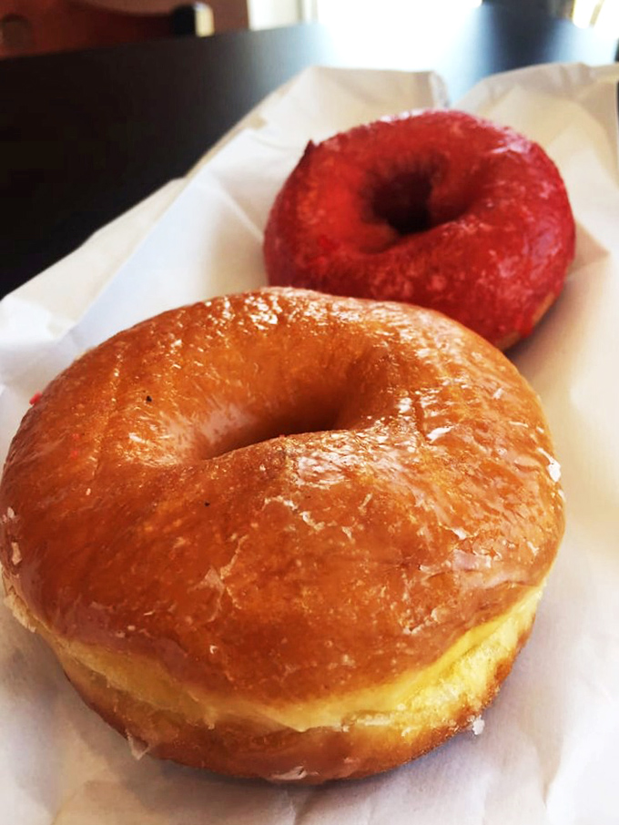Glazed perfection that proves simplicity still reigns supreme. That red-frosted companion is the wild friend who gets all the attention, but the classic always satisfies.