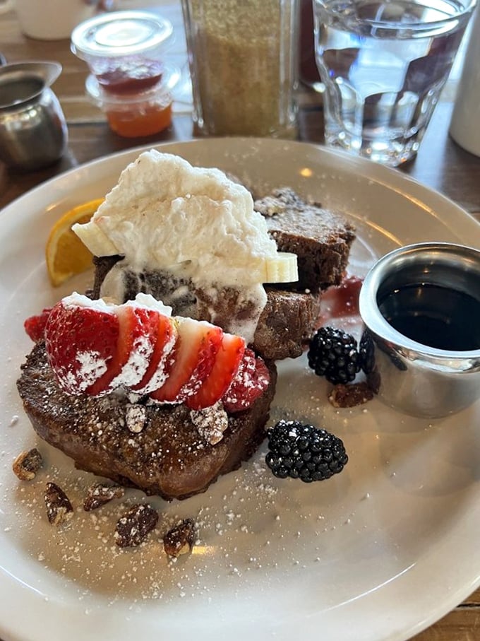 French toast transformed into dessert-for-breakfast territory, with berries and cream standing by. The breakfast that makes you feel like you're getting away with something.