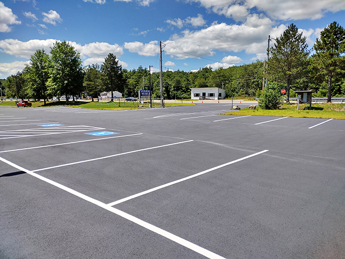 The spacious parking area welcomes racing enthusiasts from across New England, with the museum's sign visible among the trees.