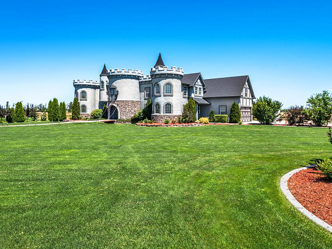 The castle's impressive silhouette stands against Idaho's blue sky, surrounded by emerald lawns that seem to whisper, "Yes, you really are in a fairy tale."