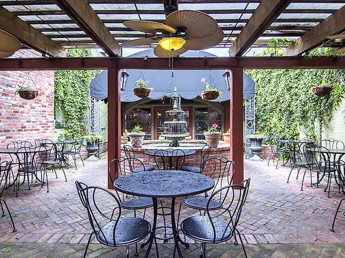 The courtyard dining area whispers "stay awhile" through ivy-covered walls and wrought iron chairs that have witnessed countless perfect evenings.