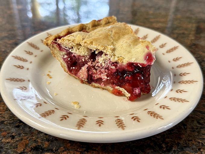Berry pie with a golden crust that crackles with buttery promise. The kind of dessert that makes you consider ordering a second slice before finishing the first.