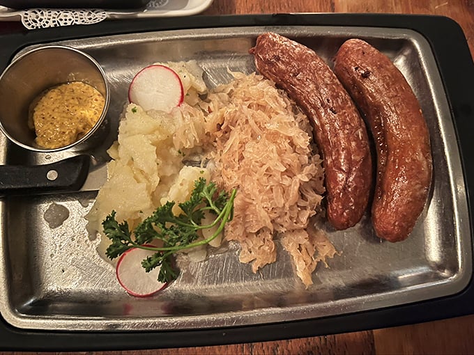Sausages that have achieved perfect doneness, nestled beside sauerkraut that's transcended its humble cabbage beginnings.