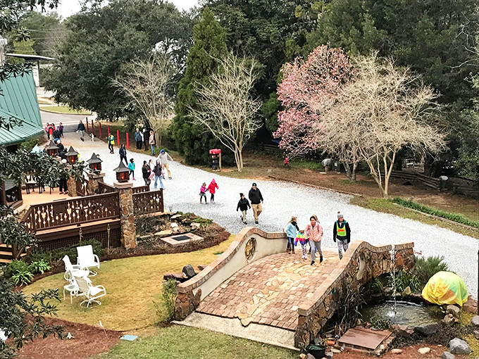 A bird's-eye view of the magic! Visitors traverse the stone bridge while flowering trees add splashes of color to this fantastical landscape.